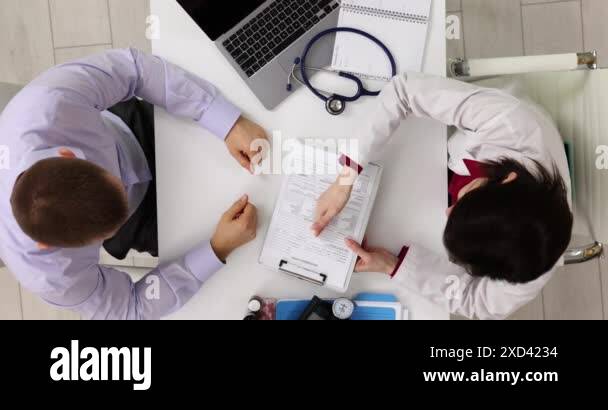 Doctor shows test results to patient explaining positive dynamics. Man ...