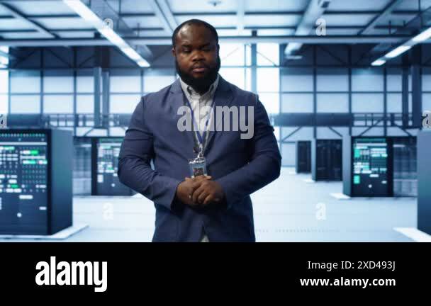 Technician walking between server rows in data center, doing yearly ...