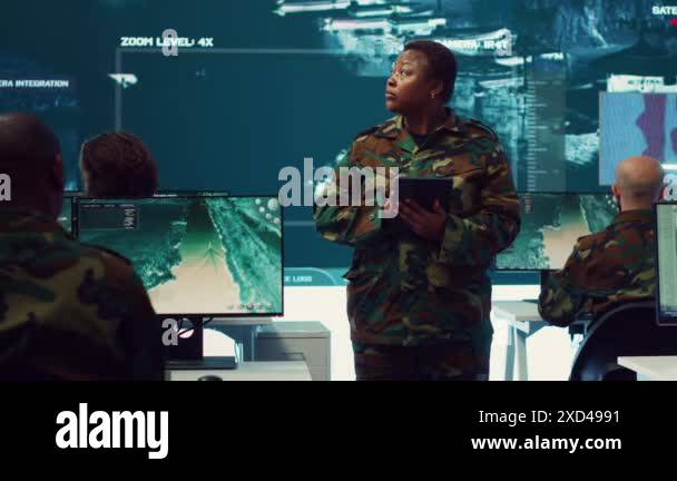 Female military officer supervising radar surveillance footage to input ...
