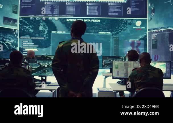 Staff sergeant monitoring satellite live imagery on a big screen ...