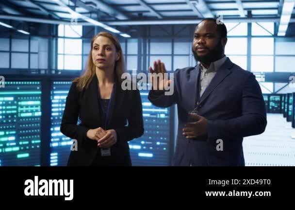 Teamworking colleagues looking at holograms in data center, working together. Server hub IT ...