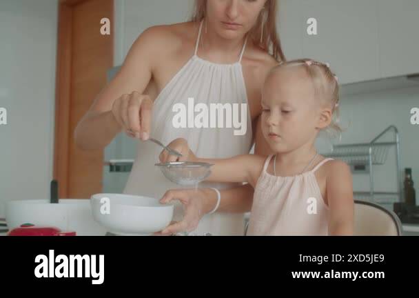 mother and daughter making waffles together on a white kitchen Stock ...