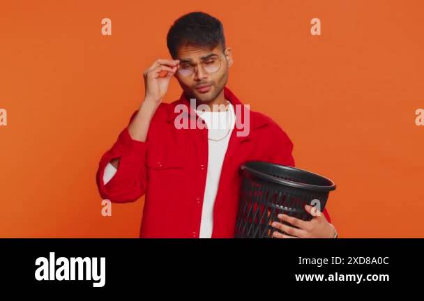 Indian young man taking off throwing out glasses into bin after medical ...