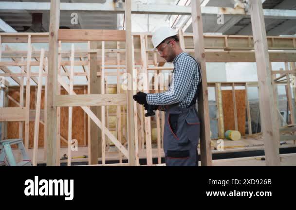 Worker carpenter assembling a modular house. Process of construction ...