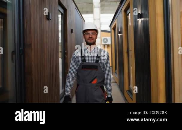 Windows installer in uniform walking with tools near modular home ...