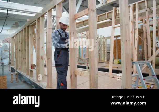 Worker carpenter assembling a modular house. Process of construction ...