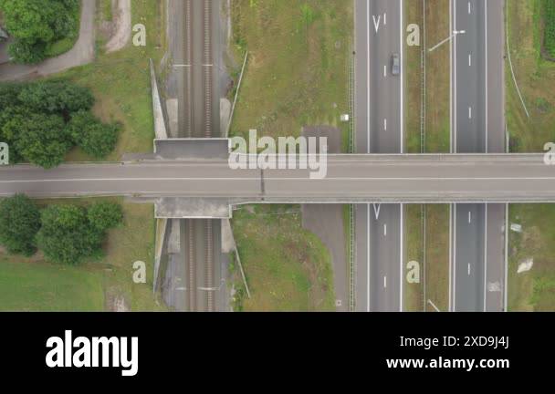 The overhead view shows a highway overpass and railroad crossing with ...
