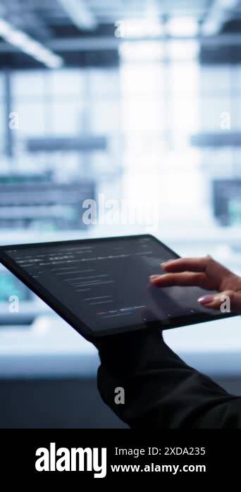 Vertical video System administrator doing annual checkup using tablet to prolong data center ...