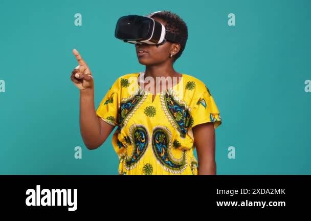 Gorgeous girl in ethnic clothes using vr glasses against blue ...