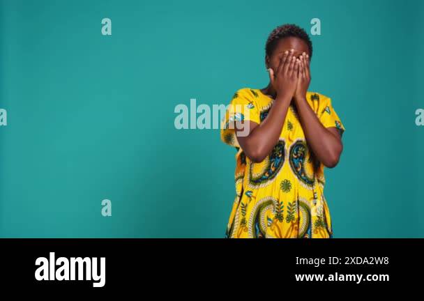 Horrified young woman covering her eyes to avoid seeing something ...