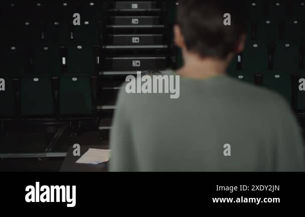 Experienced female casting director watching actor performing on stage ...