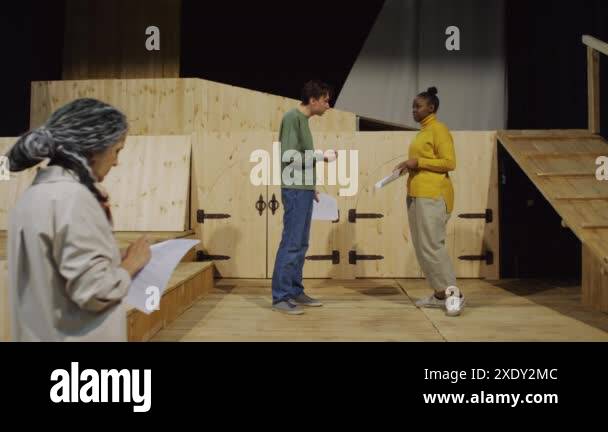 Young African American actress and Caucasian actor holding printed play ...