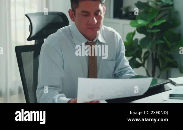 Professional engineer looking at phone while working on tablet with ...