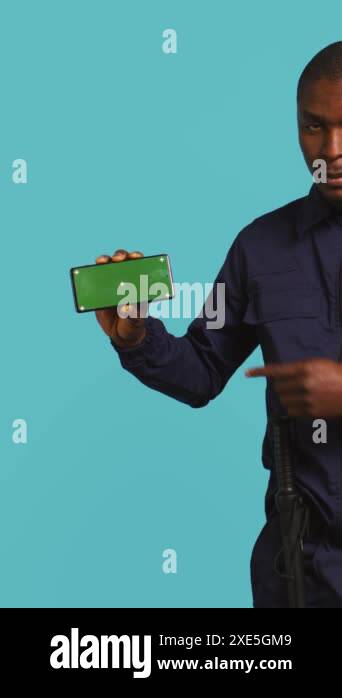 Vertical video Joyful security guard working protection job presenting ...