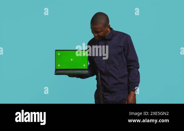 Portrait of happy security guard at work showcasing green screen laptop ...
