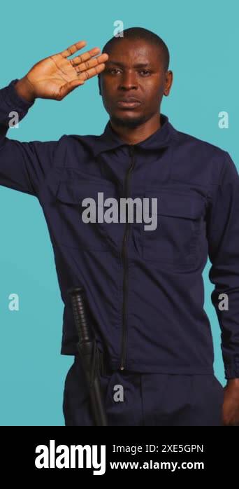 Vertical video Security guard doing salute hand gesture, preparing to ...