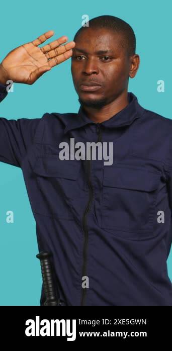 Vertical video Security guard doing salute hand gesture, preparing to ...