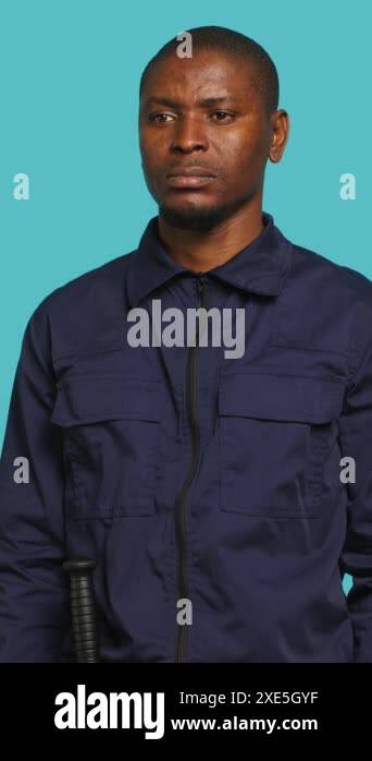 Vertical video Upbeat security guard greeting people, preventing ...