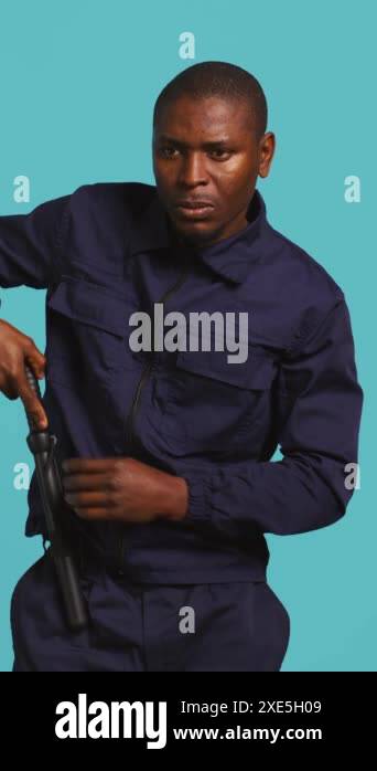 Vertical video Security guard turning on flashlight and preparing baton ...