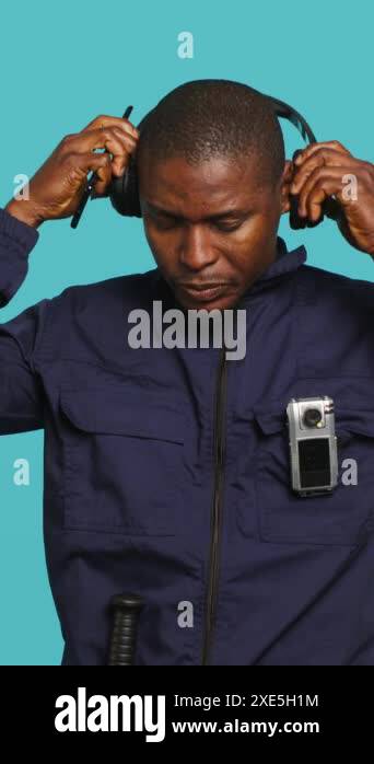 Vertical video Security guard equipped with bodycam listening music ...