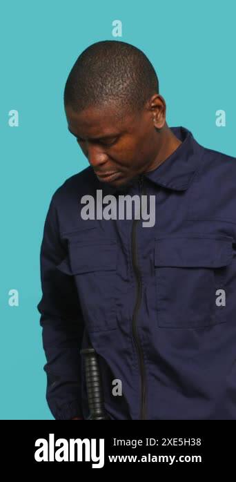 Vertical video Security guard turning on flashlight, being tasked with ...