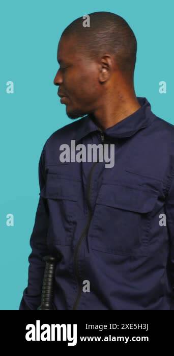 Vertical video Portrait of security guard looking around while ...