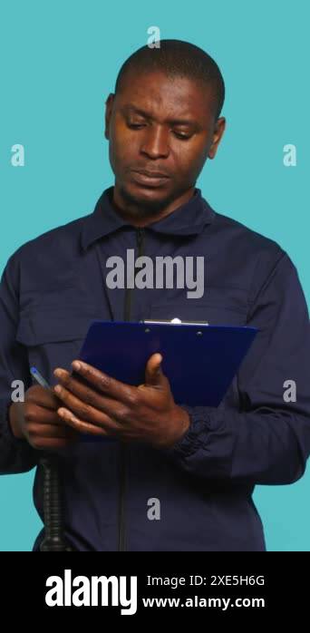 Vertical video Portrait of security guard holding clipboard, taking ...