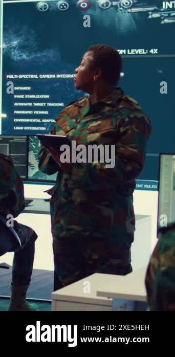 Vertical Video Female military officer supervising radar surveillance footage to input and ...