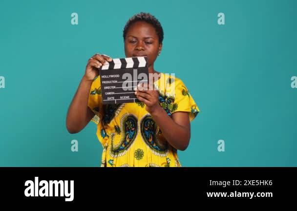 Young woman movie producer clapping filming slate to cut a scene ...
