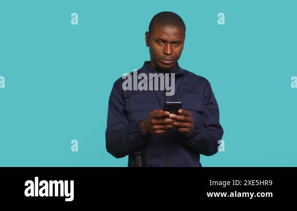 Security guard using smartphone, taking break during protection job ...