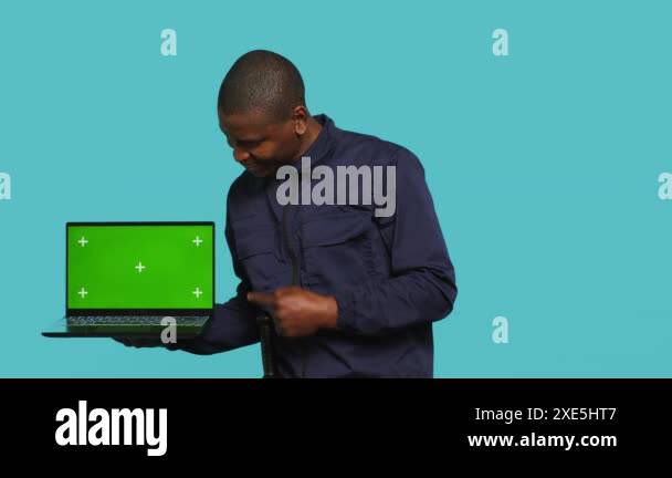 Portrait of happy security guard at work showcasing green screen laptop ...