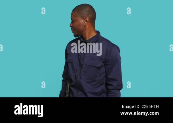 Portrait of security guard looking around while overseeing premises ...