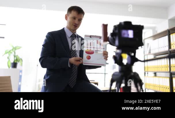Successful young businessman records video of lesson on economics using ...