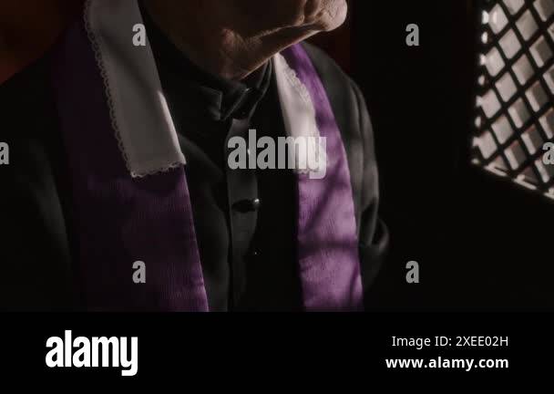 Close up shot of senior priest in traditional cassock and stole sitting ...