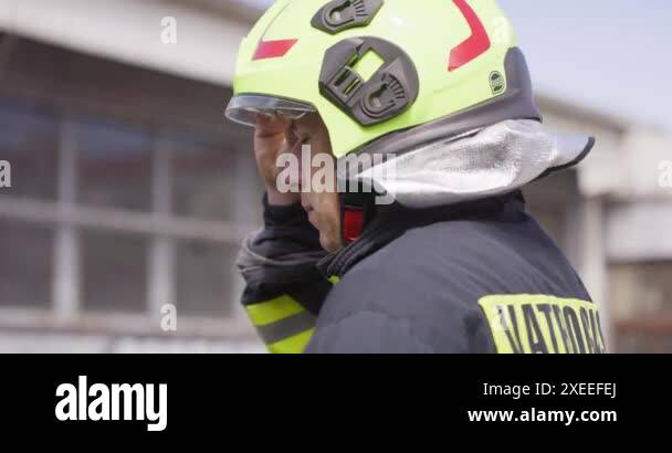A close-up shot focuses on a firefighters face as they discuss an ...