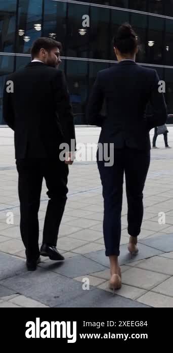 Back view. Colleagues, man and woman, have positive conversation ...