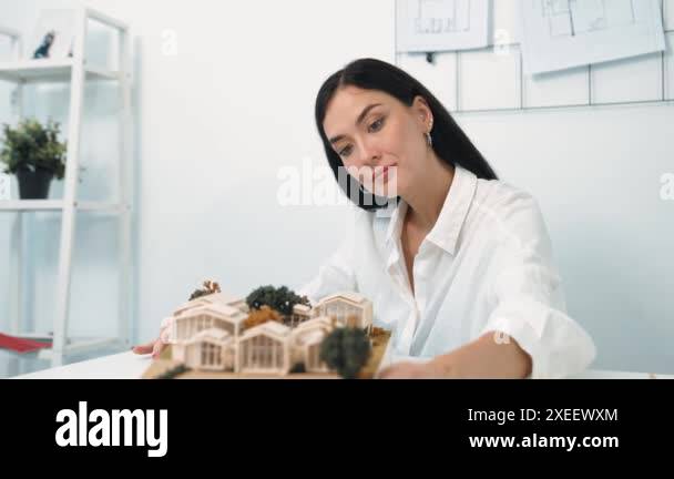 Close up of skilled young beautiful caucasian architect lift house ...