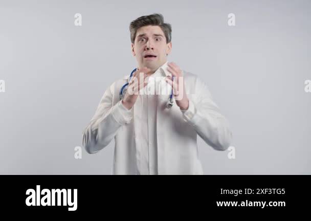 Frightened shocked physician man in white medical coat form afraid of ...