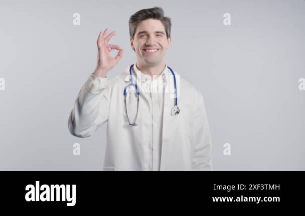 Positive mature 30s physician in white medical coat form makes OK, okay ...