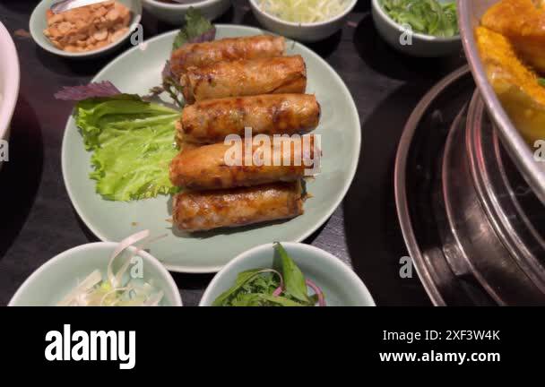 Vietnamese fried spring rolls Nem Ran on table near of traditional dish ...