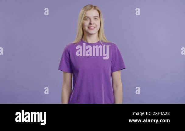Gorgeous woman in purple casual outfit showing yes signal, nods head ...