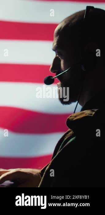 Vertical video US Air Force dispatcher looking at surveillance transmission on device, relaying ...