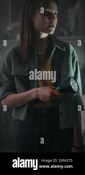 Vertical medium long shot of Caucasian teenage girl flashing torch and ...