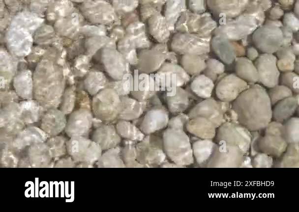 CLOSE UP, TOP DOWN: Sea water harmoniously flows over glistening white ...