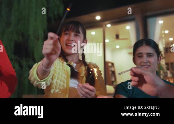 Happy family holding glowing sparkler in holiday celebration party at ...