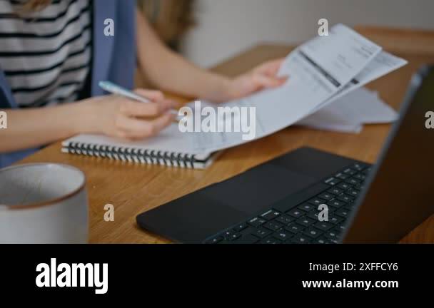 Lady hands reviewing paperwork coordinating tasks on laptop closeup ...