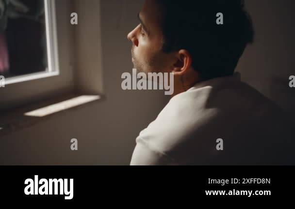 Sleepless man looking out window with pensive mood closeup. Tired guy ...