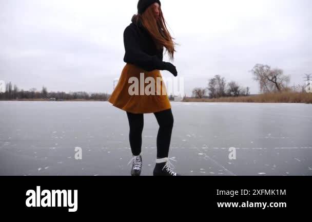 Sportswoman in figure skates sliding backwards on ice surface outdoor ...