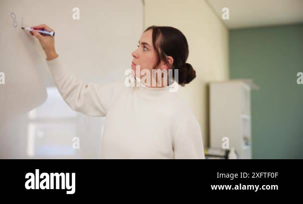 Teacher, math and writing on whiteboard in classroom for learning ...