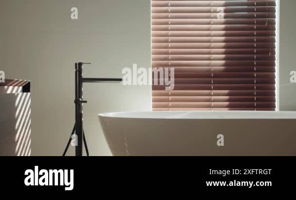 Elegant modern bathroom featuring a freestanding bathtub with a steel ...